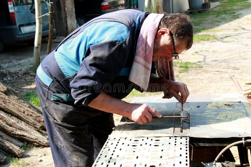 A Man Sharpening a Saw with a Tool Stock Photo - Image of workingdesk ...