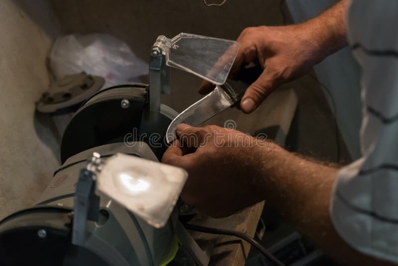 Man Sharpens a Knife on an Electric Grindstone Stock Image - Image of ...