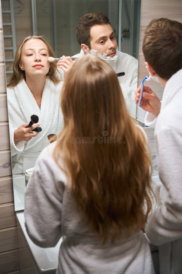 Man Shaving His Beard Woman Applying Make-up in the Bathroom Stock ... Man Shaving His Beard Woman Applying Make-up in the Bathroom Stock ...