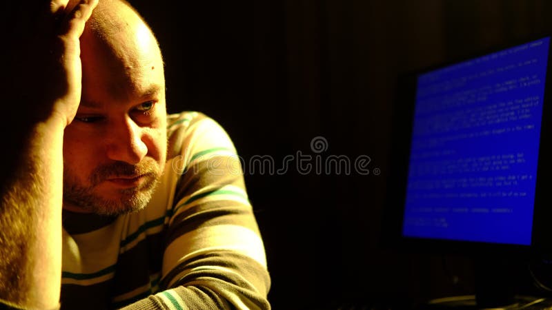 A Man is Shocked in Front of a Blue Computer Screen in the Dark. Stress ...