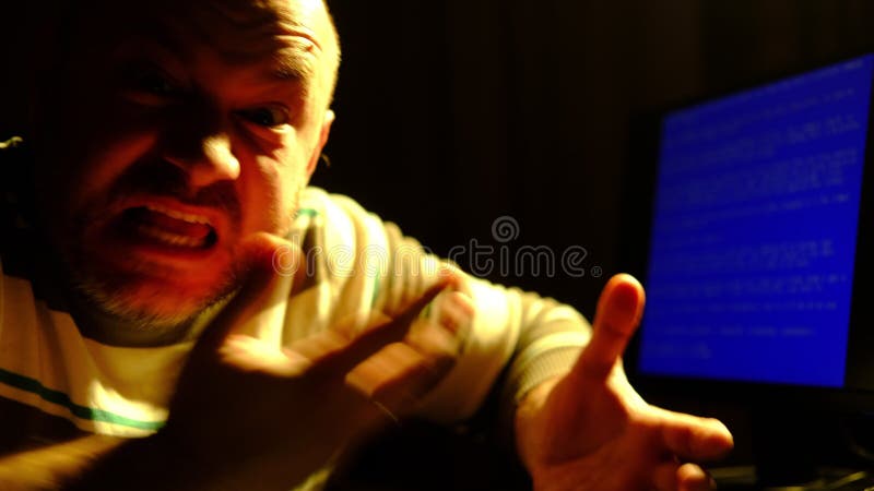 A Man is Shocked in Front of a Blue Computer Screen in the Dark. Stress ...