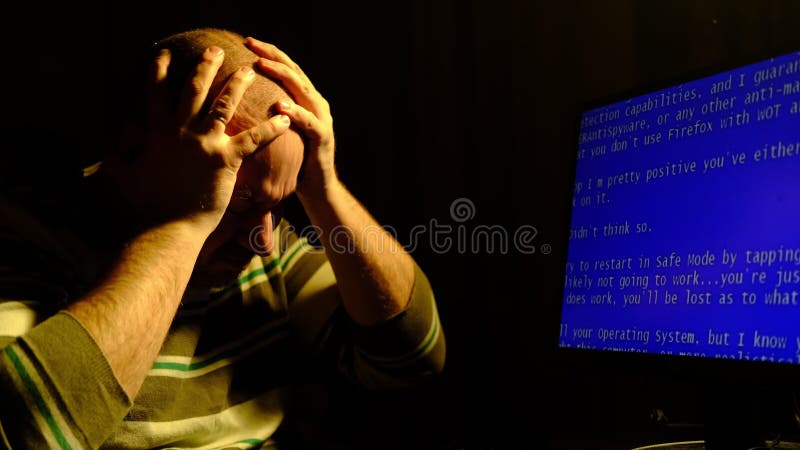 A Man is Shocked in Front of a Blue Computer Screen in the Dark. Stress ...