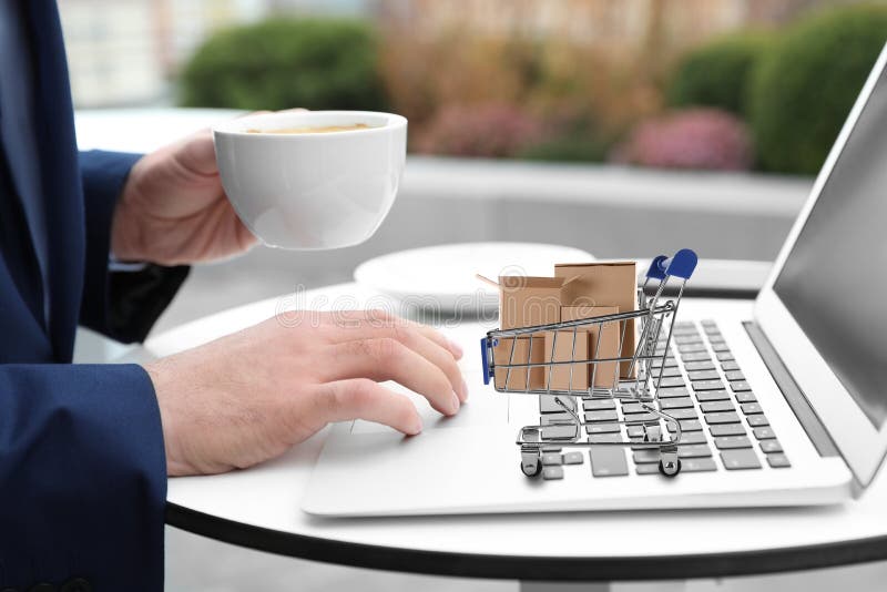 Man Shopping Online Using Laptop, Small Cart with Boxes Stock Photo ...