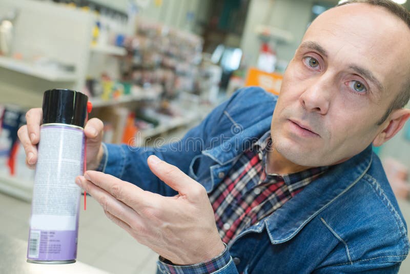 Man showing aerosol can stock image. Image of store - 118892781