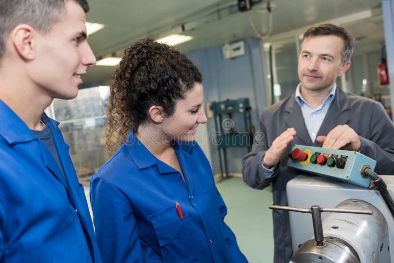 Man Showing Controls Machine To Two Trainees Stock Image - Image of ...