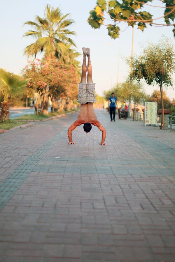 Man Showing Impressive Strength, Doing a Handstand in Street Stock ...