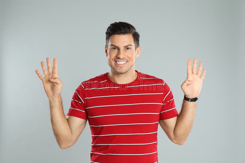 Man Showing Number Eight with His Hands on Grey Background Stock Image ...