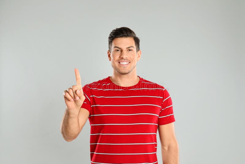 Man Showing Number One with His Hand on Grey Background Stock Photo ...