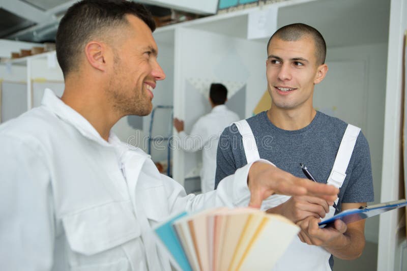 Man Showing Paint Samples To Young Coworker Stock Image - Image of desk ...