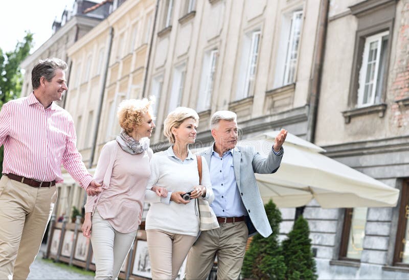 Man Showing Something To Friends while Walking in City Stock Photo ...