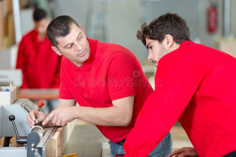 Man Showing Trainee How To Set Up Machine in Workshop Stock Image ...