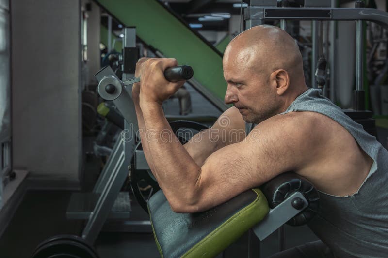 Man in a Simulator Performs an Exercise for Pumping Biceps in the Gym ...