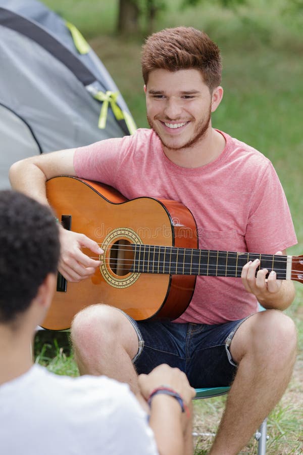 Man Singing and Playing Guitar Outside Tent Stock Image - Image of tent ...