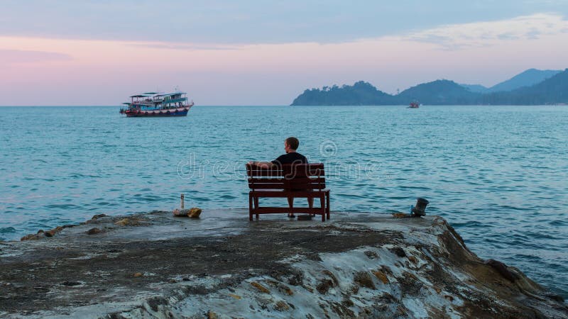 A Man Sits Alone on a Bench on the Seafront Promenade. Stock Photo ...