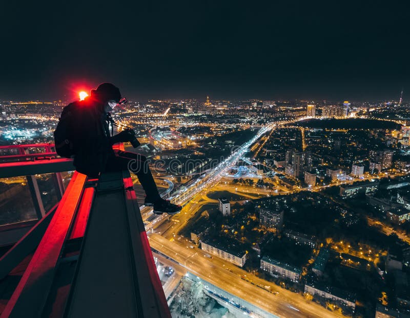 Man Sits with Camera on Skyscraper Near Beacon at Stock Photo - Image ...