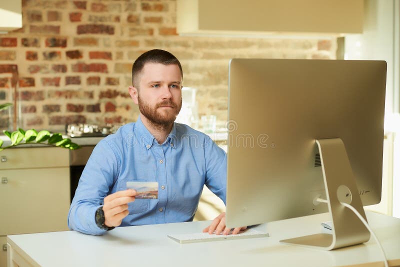 Man Sits in Front of the Computer and Types Card Information on an ...