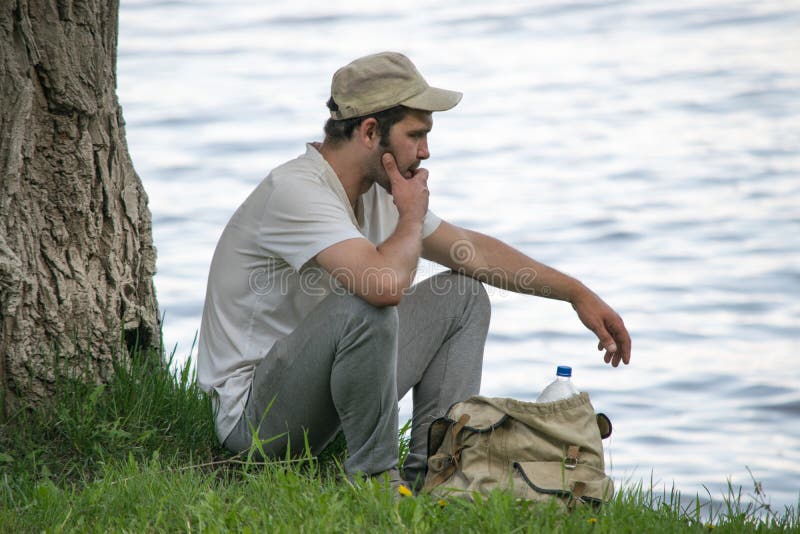 Young Man is Resting Near a Tree on the River Bank Stock Photo - Image ...
