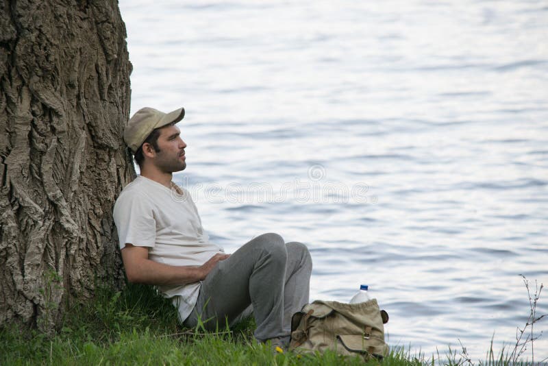 Young Man is Resting Near a Tree on the River Bank Stock Photo - Image ...