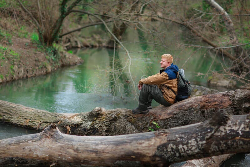 Man Sits on a Log by the Green River Stock Image - Image of people ...