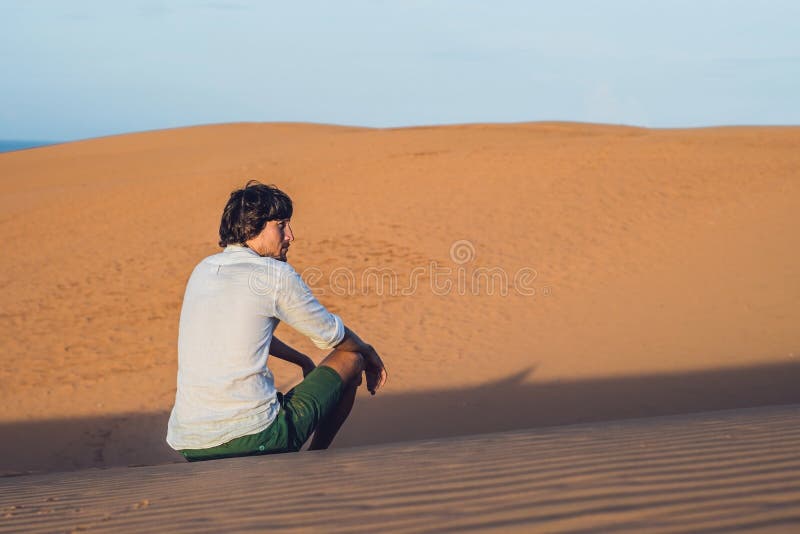 A Man Sits on the Sand in the Desert Stock Image - Image of mountain ...