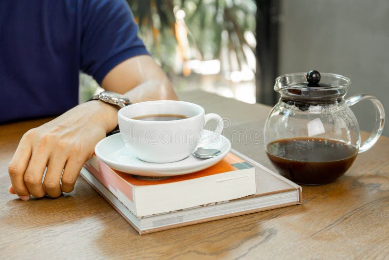 Man Sits on Table with Coffee on the Book in Coffee Shop. Stock Photo ...