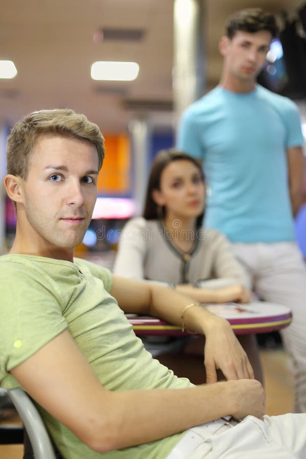 Man Sits at Table; Other Man Stands and Woman Sits Stock Image - Image ...