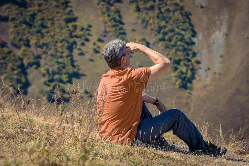 A Man Sits on Top of a Mountain and Enjoys the Scenery of the Caucasus ...