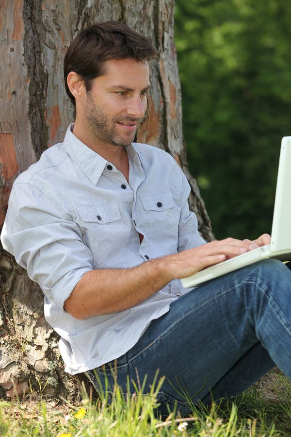 Man sitting against a tree stock image. Image of wellness - 20866971