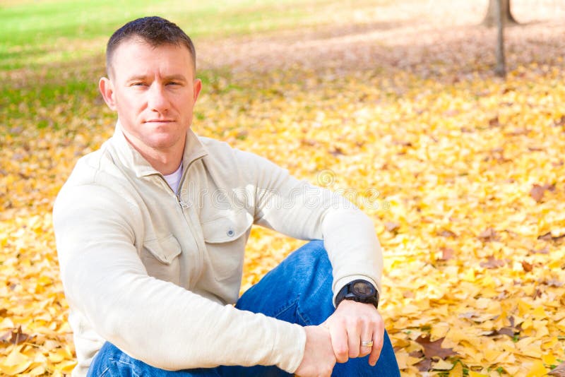 Man Sitting on Autumn Leaves Stock Photo - Image of autumn, holiday ...