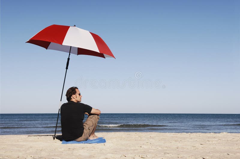 Man Sitting at the Beach stock image. Image of sideways - 30018715