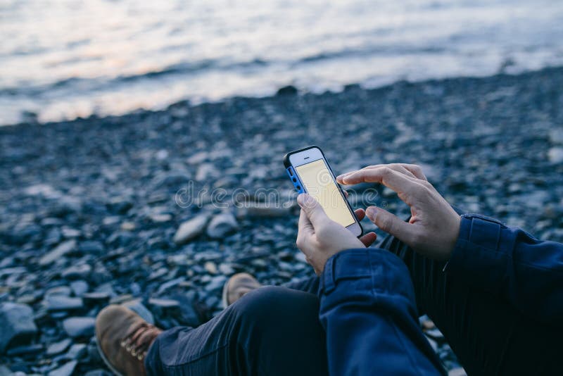Man Sitting on the Beach and Using a Cell Phone Stock Photo - Image of ...