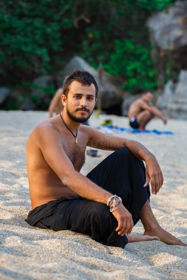 Man sitting on a beach stock photo. Image of masculine - 77935598