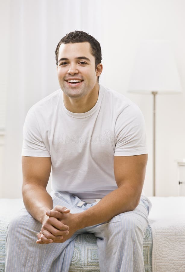 Man Sitting on Bed and Smiling Stock Photo - Image of male, person: 9913336