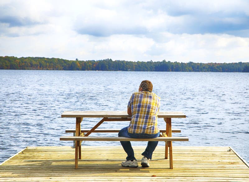 Man Sitting on a Bench in Front of a Lake Stock Image - Image of moody ...