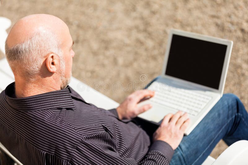 Man Sitting on a Bench Using a Laptop Stock Image - Image of bald ...