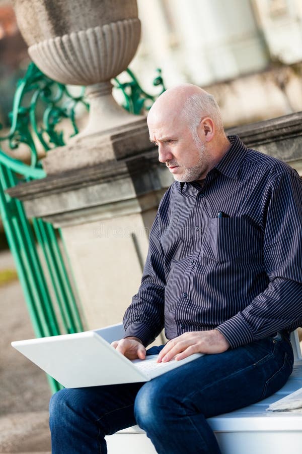 Man Sitting on a Bench Using a Laptop Stock Image - Image of mobility ...