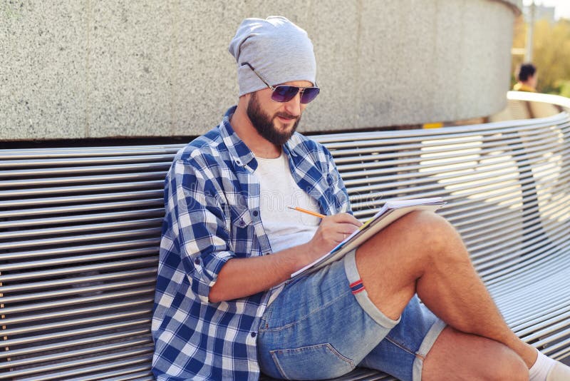 Man Sitting on Bench and Writing Stock Image - Image of handsome ...