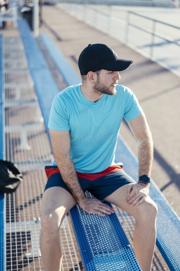 Man Sitting on a Blue Bench, Wearing a Cap Stock Photo - Image of ...