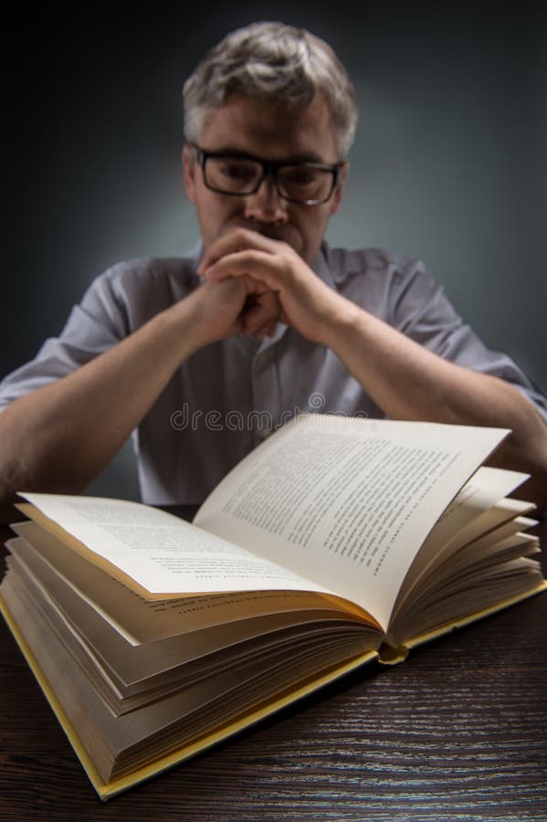 Man Sitting at Brown Table and Reading Book. Stock Image - Image of ...