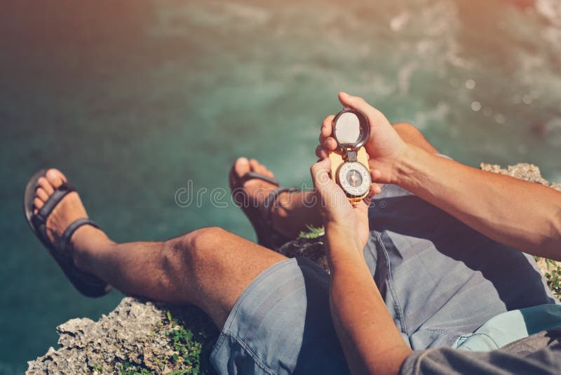 Man Sitting with Compass Above the Ocean on Cliff Stock Image - Image ...