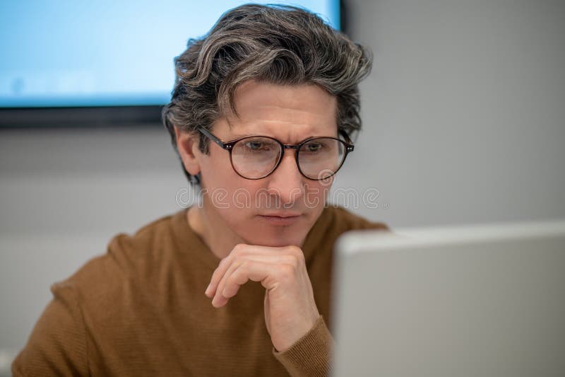 A Man Sitting at the Computer and Looking Concentrated Stock Photo ...
