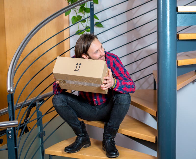 Man Sitting in Corridor and Opening a Package Stock Photo - Image of ...