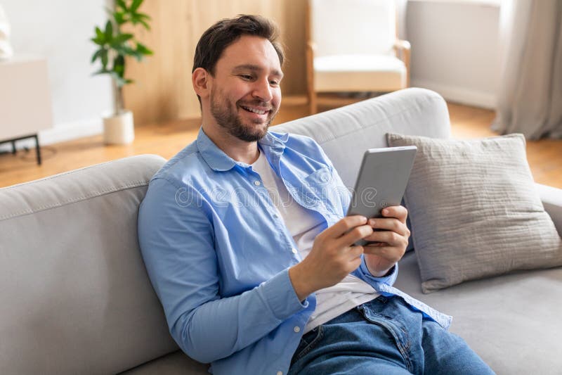 Man Sitting on Couch Using Tablet Computer Stock Photo - Image of ...