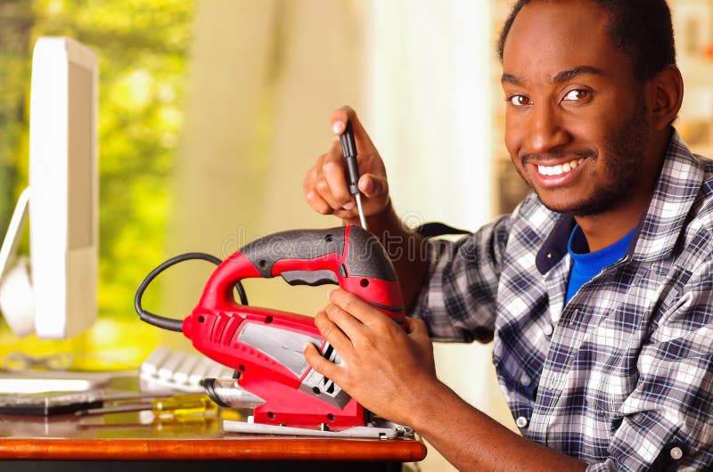 Man Sitting by Desk Repairing Handheld Jigsaw Using Screwdriver ...