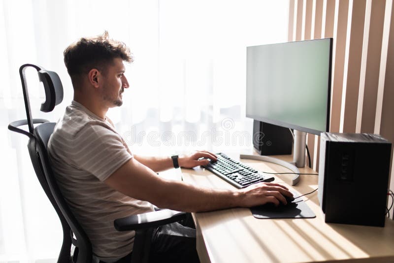 Handsome Man Sitting at Desk Working from Home on Computer Stock Photo ...