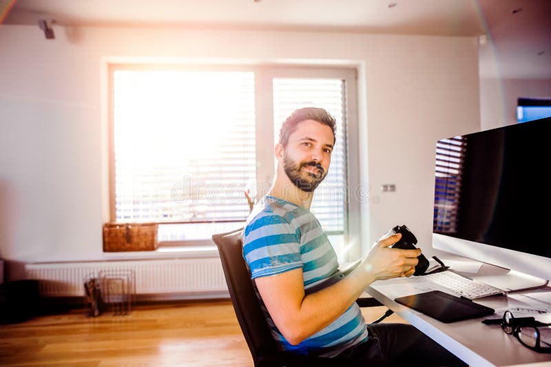 Man Sitting at Desk Working from Home Holding Camera Stock Image ...