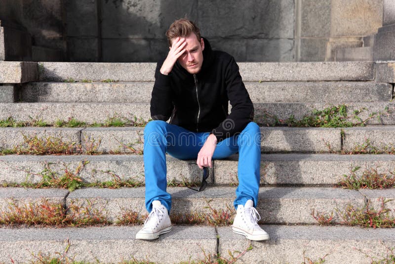 Man Sitting Down Outside Looks Worried Stock Photo - Image of holding ...
