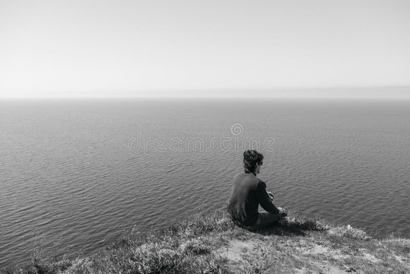 Man Sitting on Edge of Cliff at Edge Stock Image - Image of mountain ...