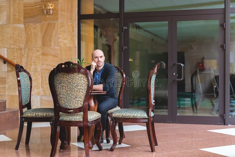 A Man Sitting at an Empty Table Waiting for a Meeting. Around Three ...