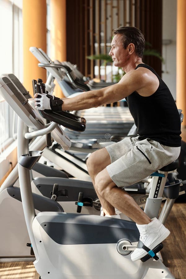 Man Sitting on Exercise Bike Stock Image - Image of sport, cardio ...